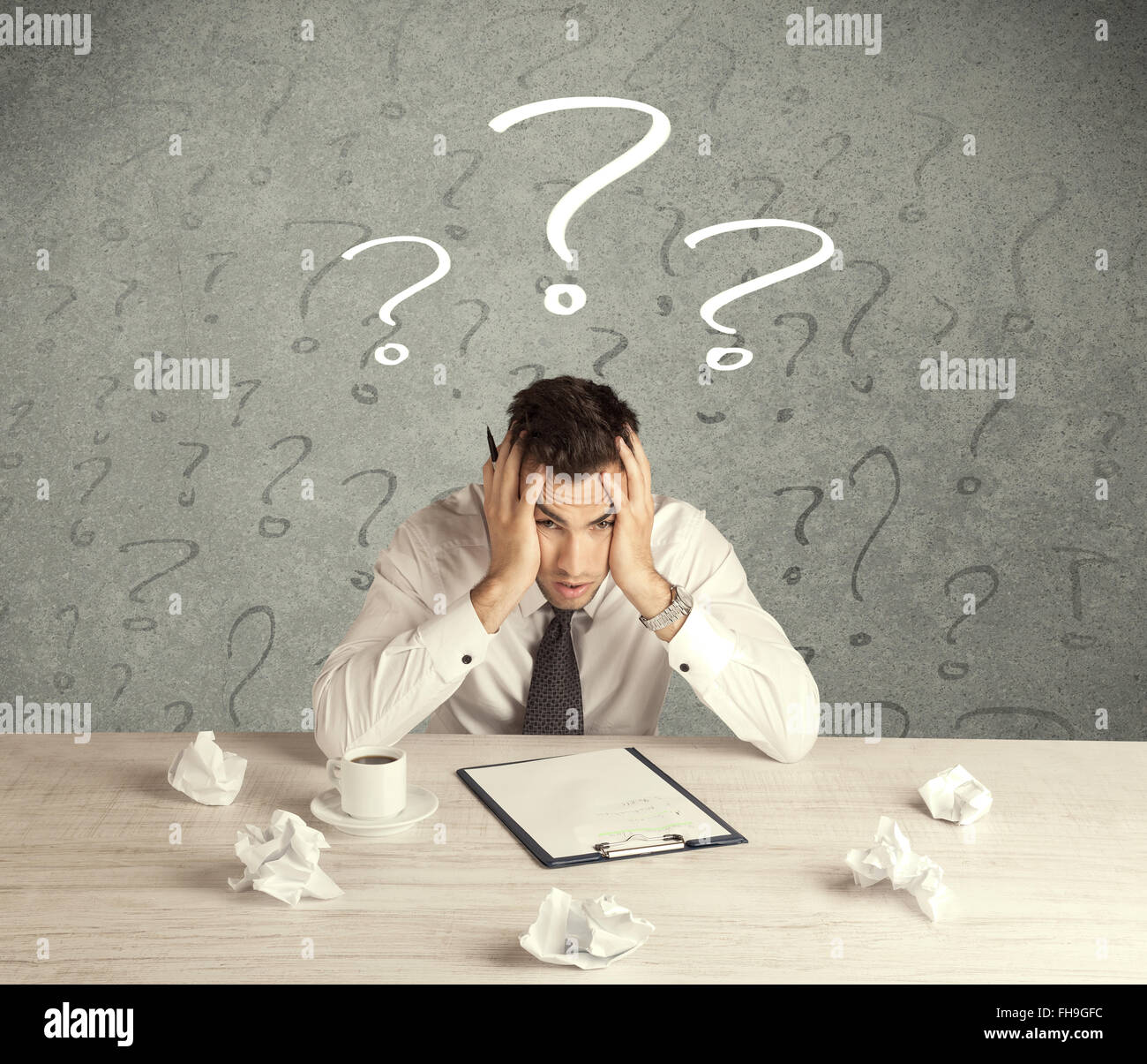 Businessman at desk with question mark Stock Photo - Alamy