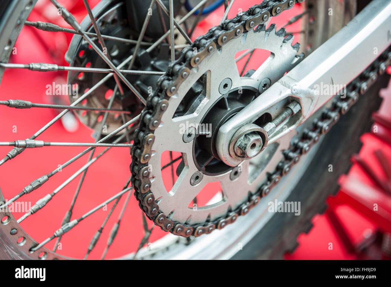 Rear chain of motorcycle on a red background Stock Photo - Alamy