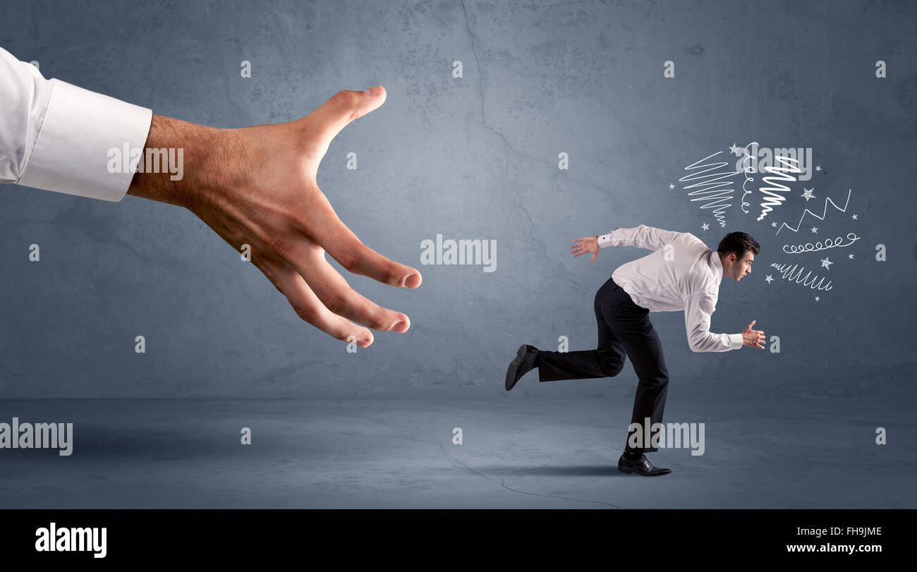 Stressful businessman running from a big hand Stock Photo - Alamy
