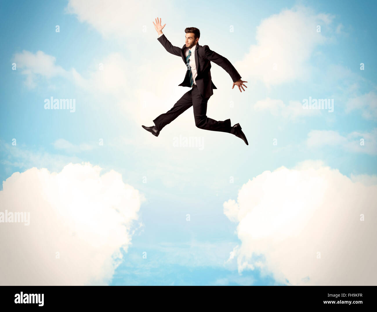 Business person jumping over clouds in the sky Stock Photo - Alamy