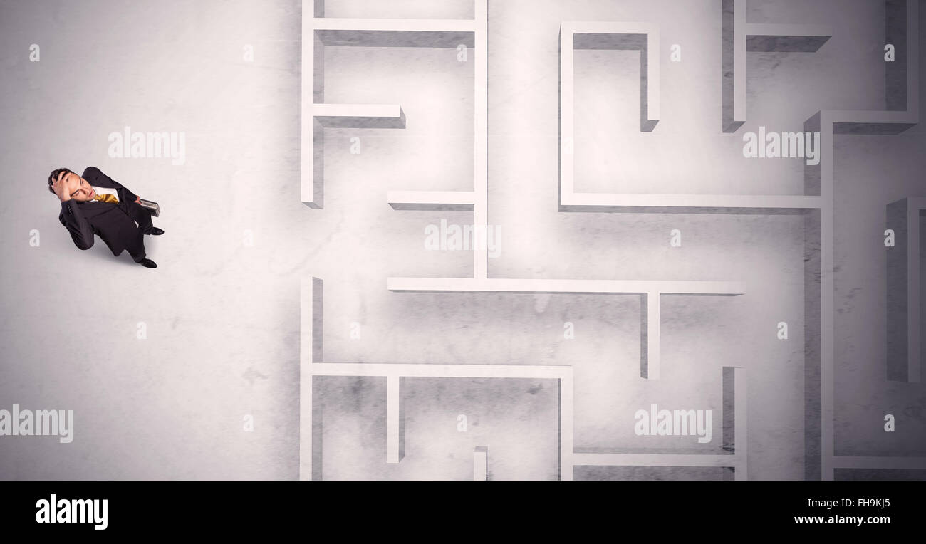 Confused businessman standing at a maze wall Stock Photo - Alamy