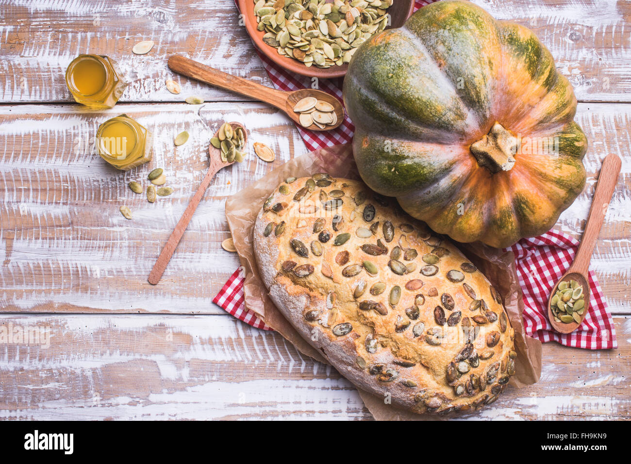 Newly baked bread with seeds and pumpkin on wooden table. Rustic style ...