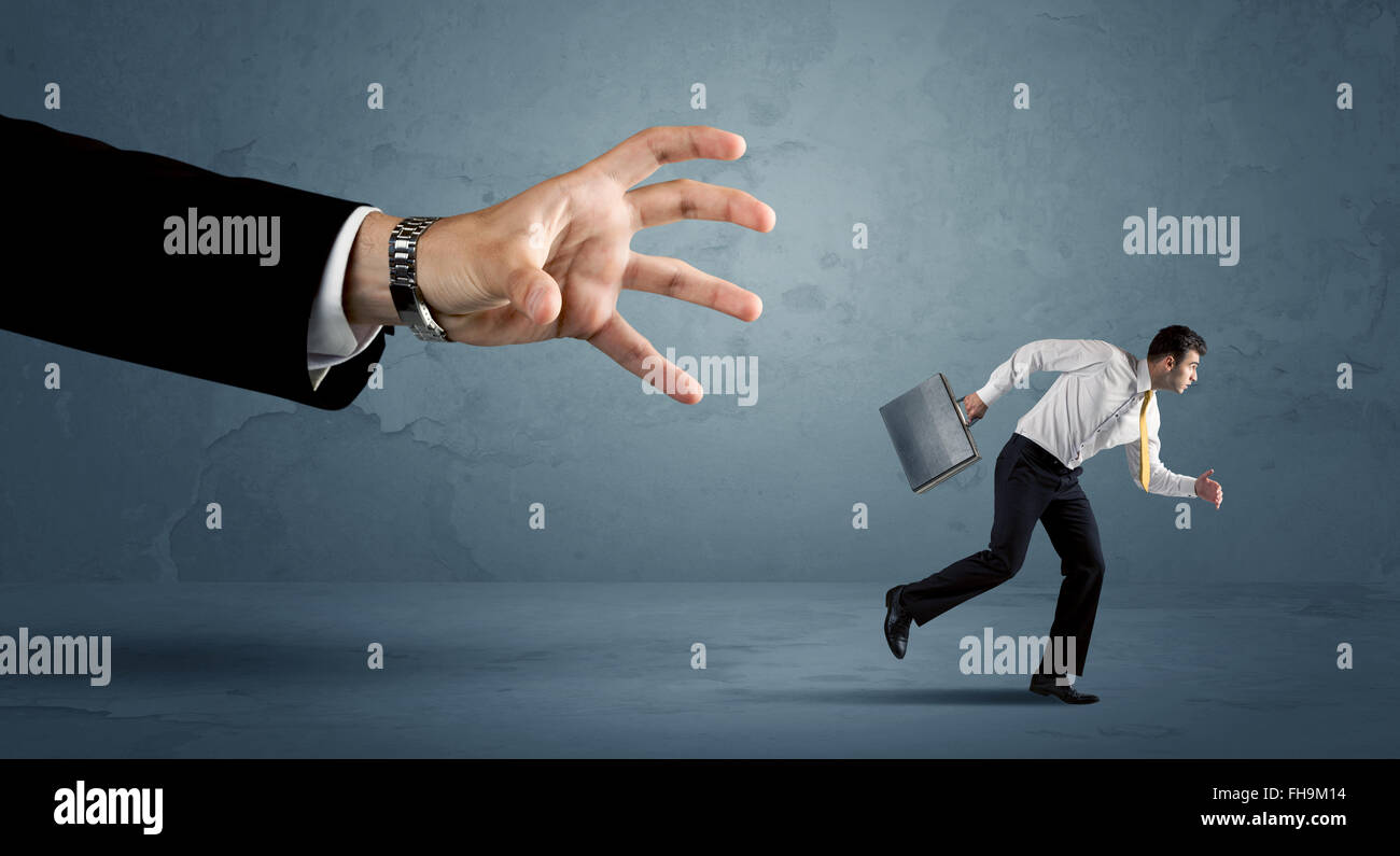 Business man running away from a huge hand concept Stock Photo - Alamy