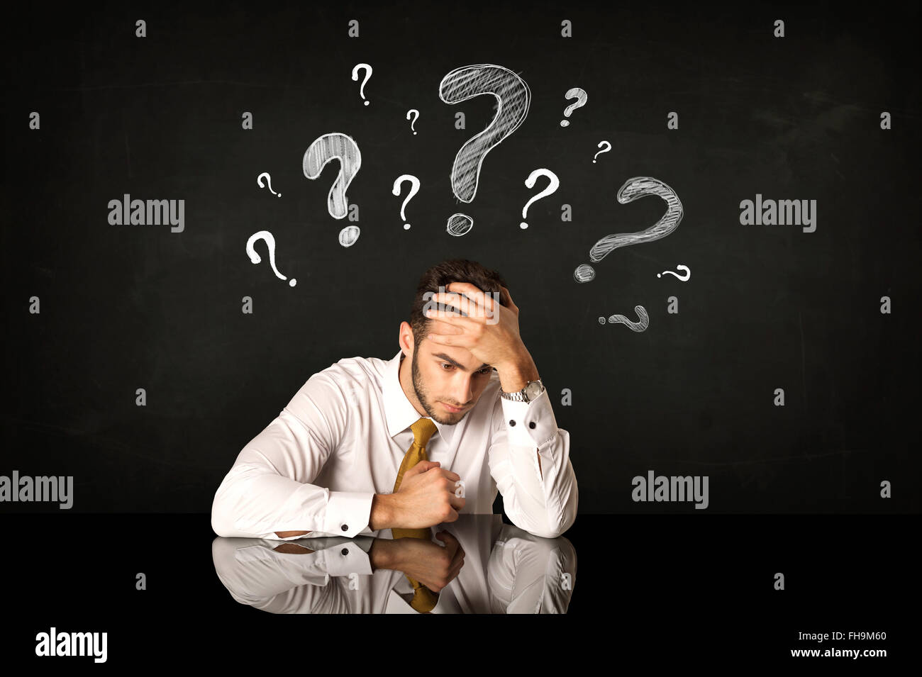 Sitting businessman under question marks Stock Photo - Alamy