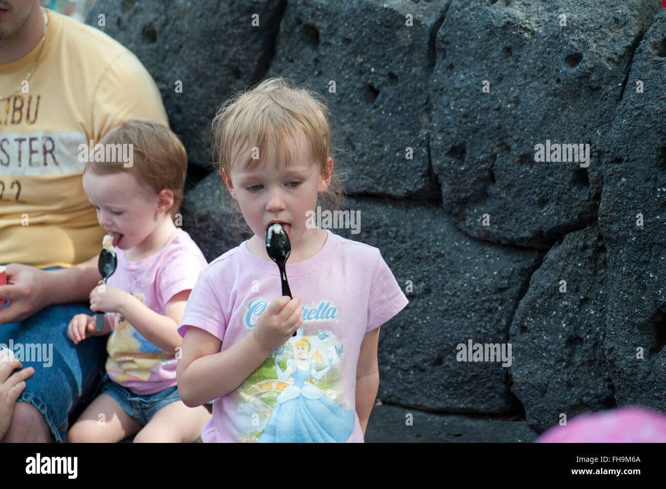 Young kids having fun eating trash food at the amusement park of Disney ...