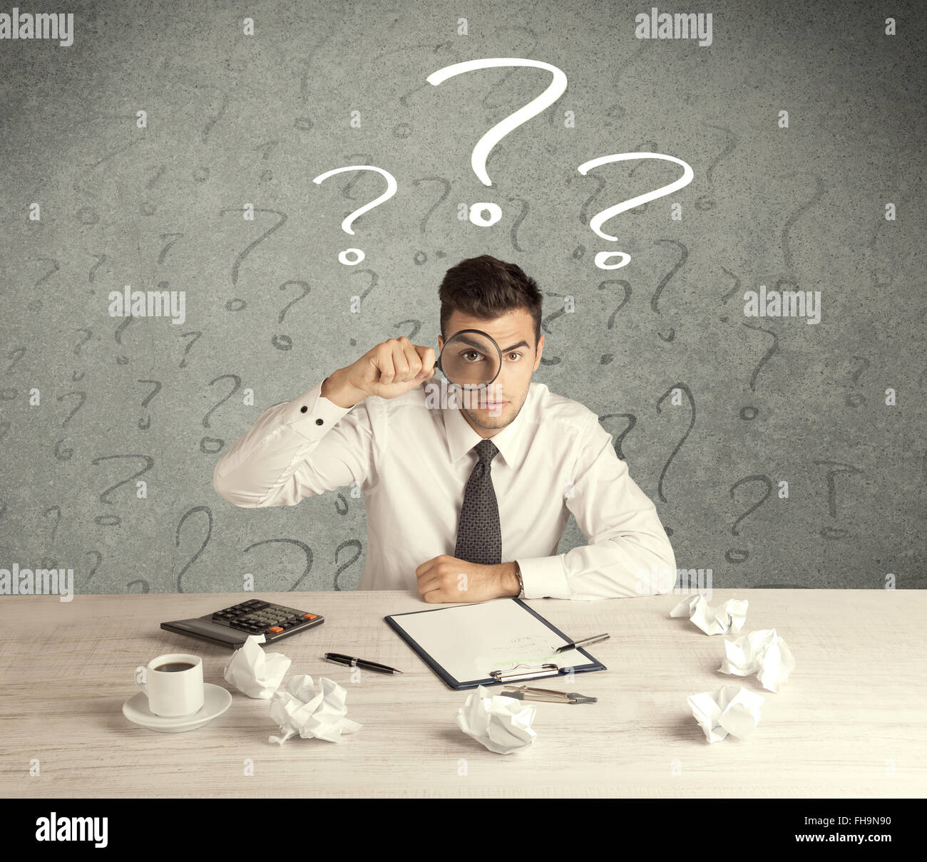 Businessman at desk with question mark Stock Photo - Alamy