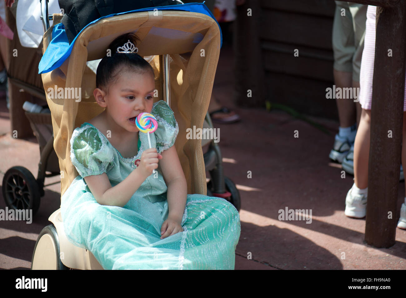 Young kids having fun eating trash food at the amusement park of Disney ...