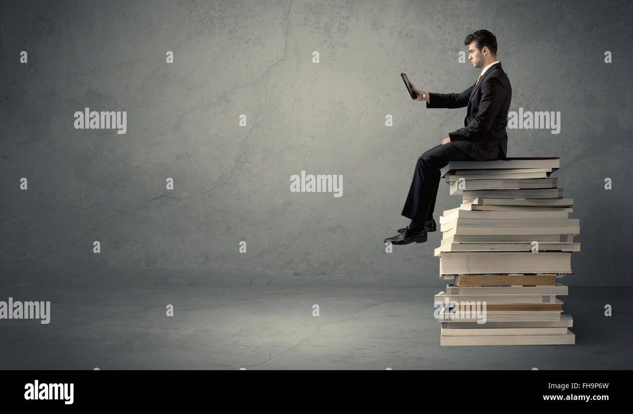 Student sitting on pile of books Stock Photo - Alamy