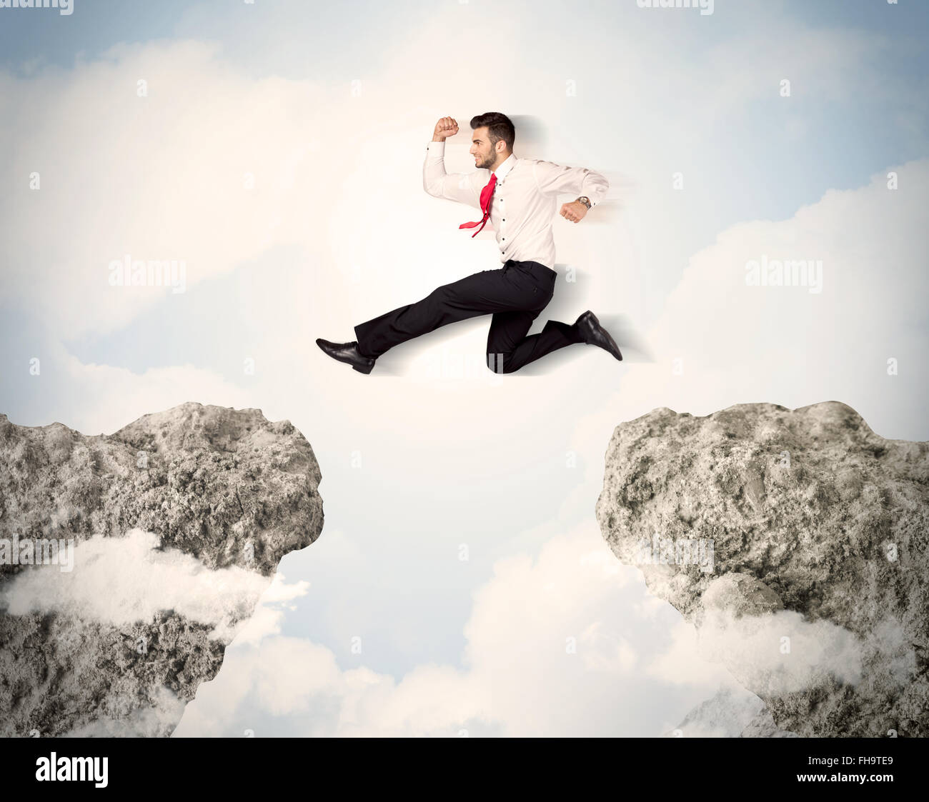 Happy business man jumping over a cliff Stock Photo - Alamy