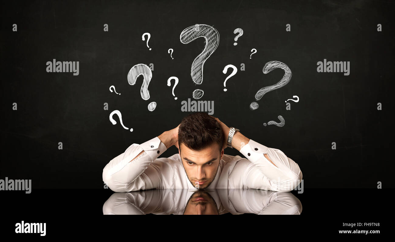 Sitting businessman under question marks Stock Photo - Alamy