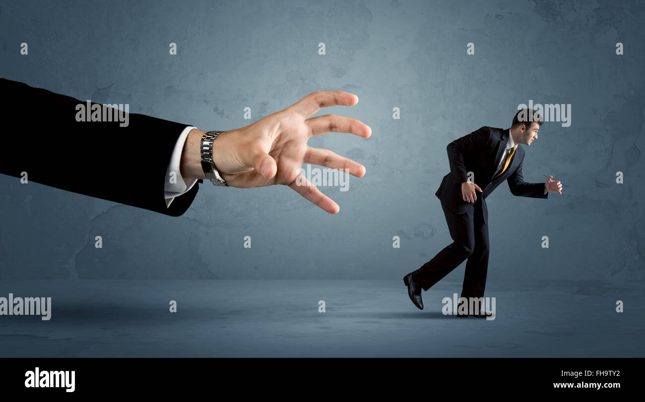 Business man running away from a huge hand concept Stock Photo - Alamy