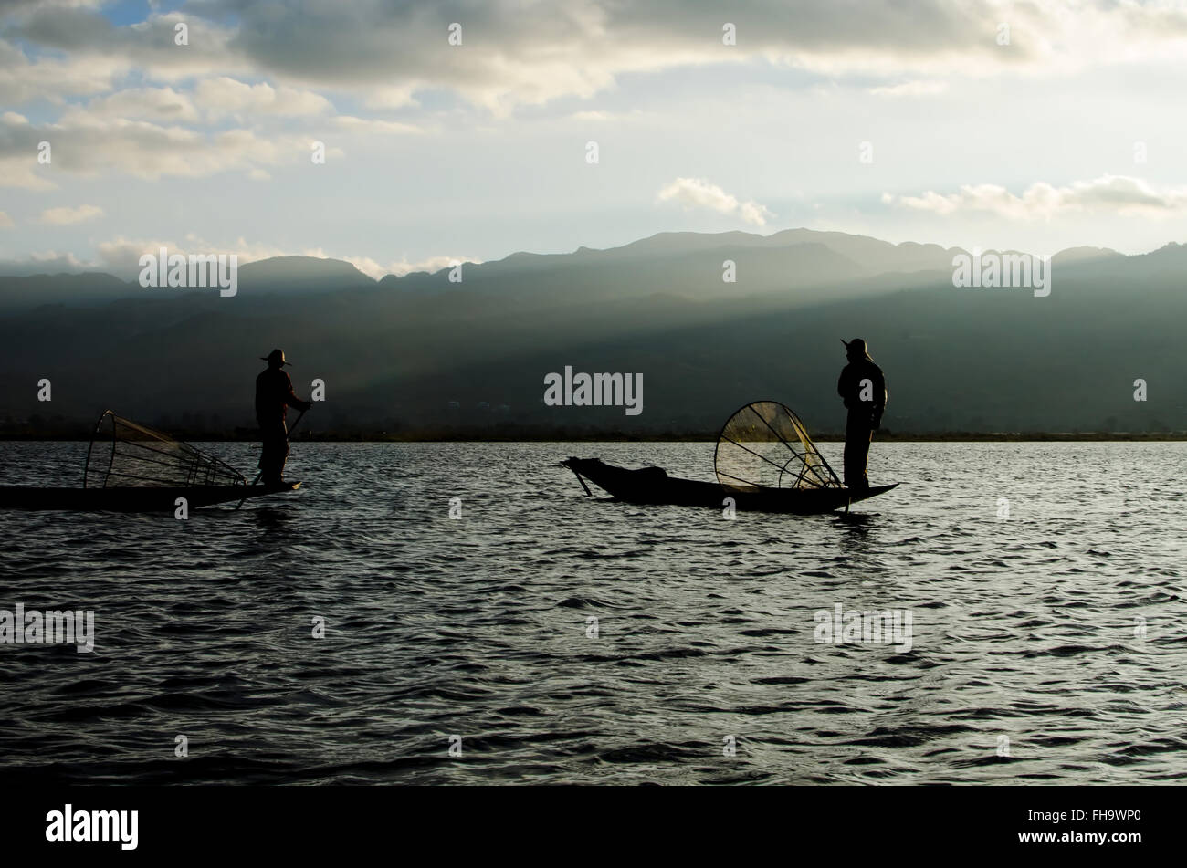Two fishermen at sunrise Stock Photo - Alamy