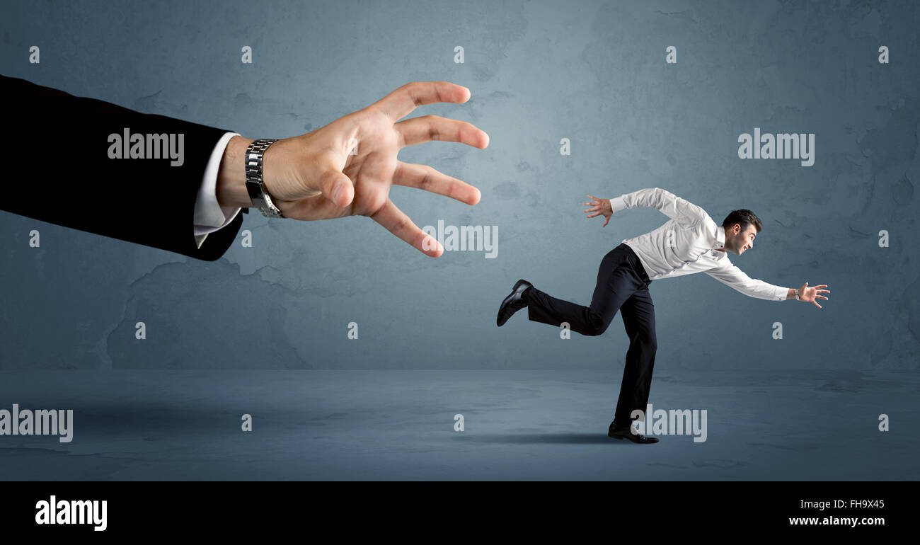 Business man running away from a huge hand concept Stock Photo - Alamy