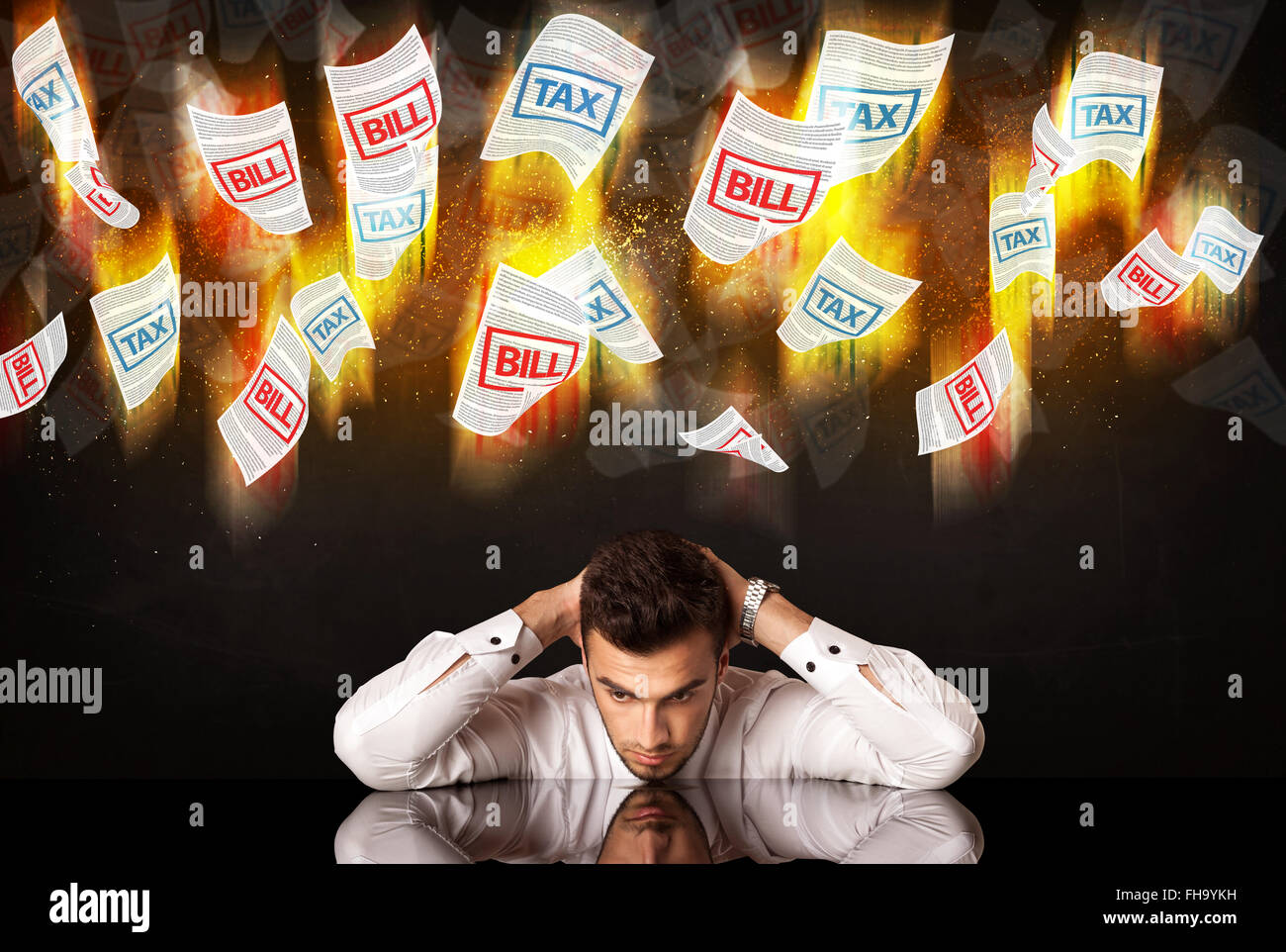 Depressed businessman sitting under burning tax and bill papers Stock ...