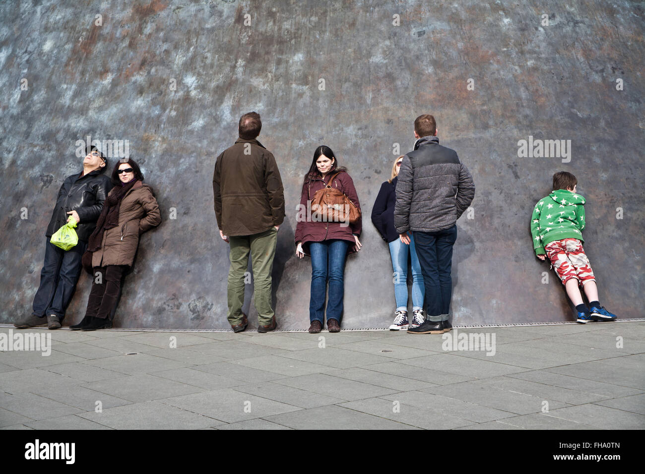 People leaning against the wall of the Observatory, Greenwich, London ...