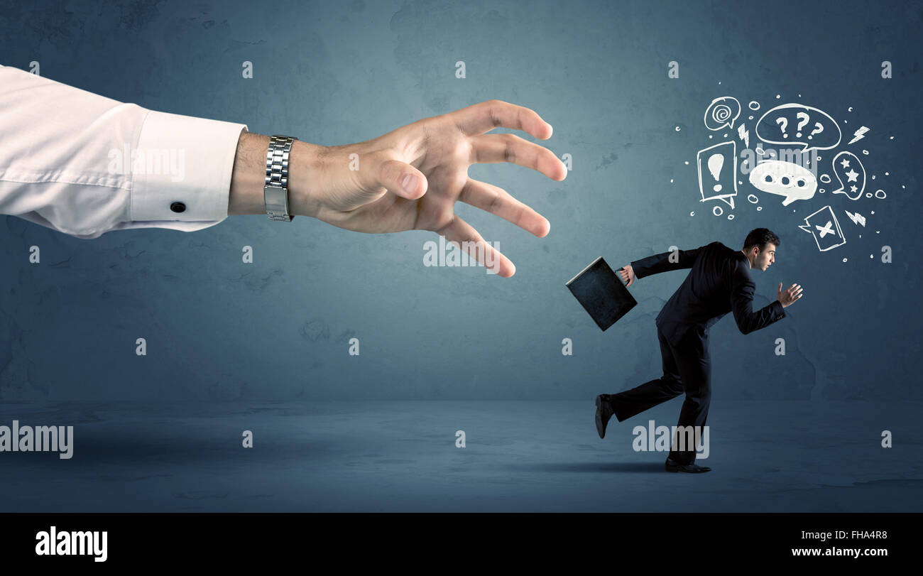 Business man running from a big hand Stock Photo - Alamy
