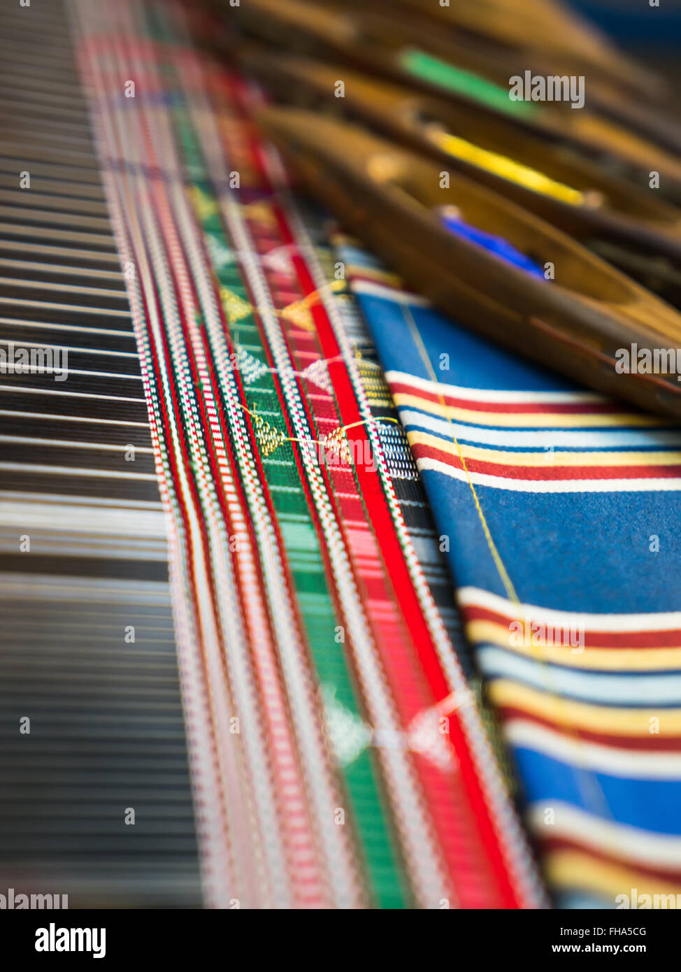 Weaving shuttles and colorful textile with pattern. Artistic shallow ...