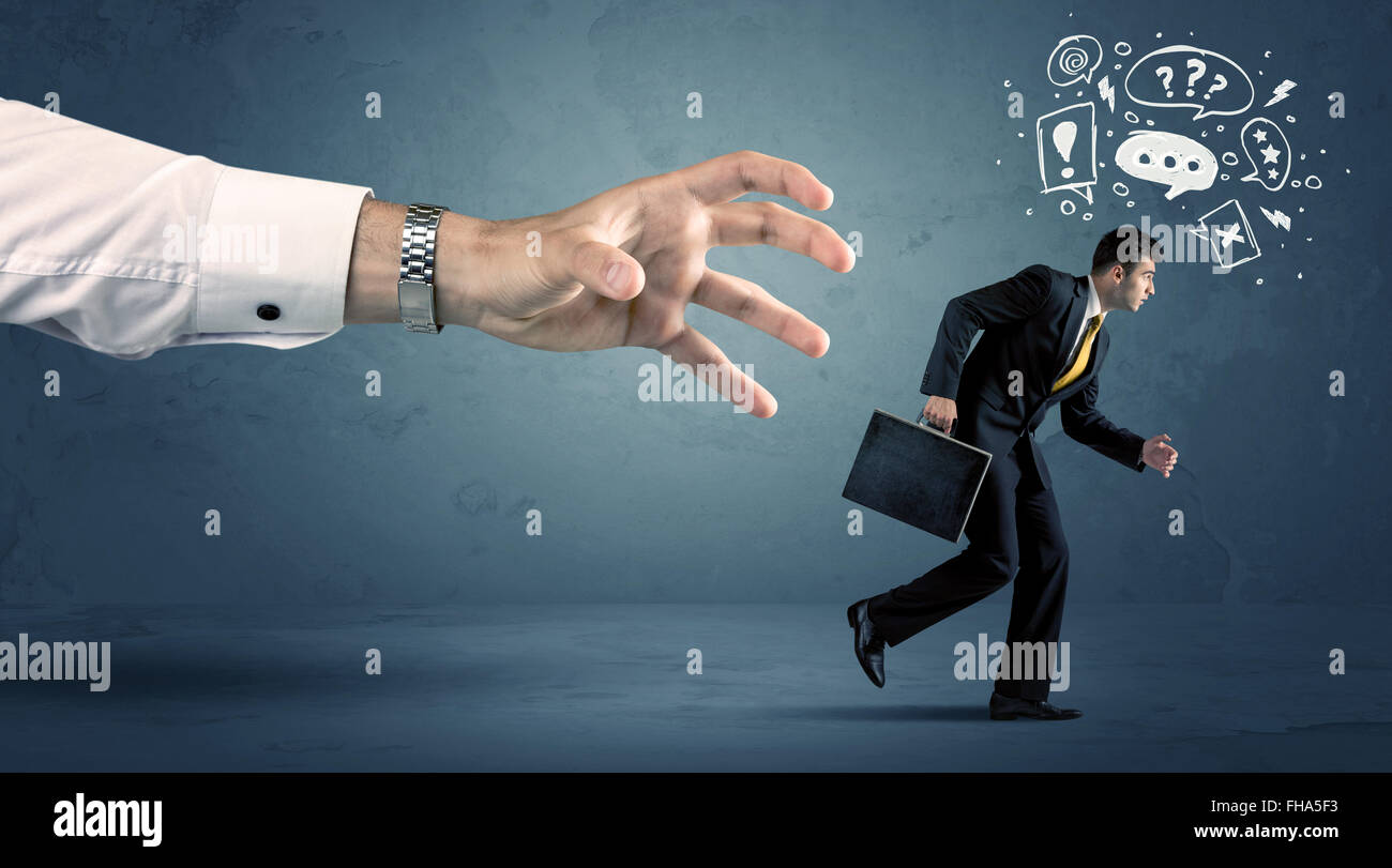 Business man running from a big hand Stock Photo - Alamy