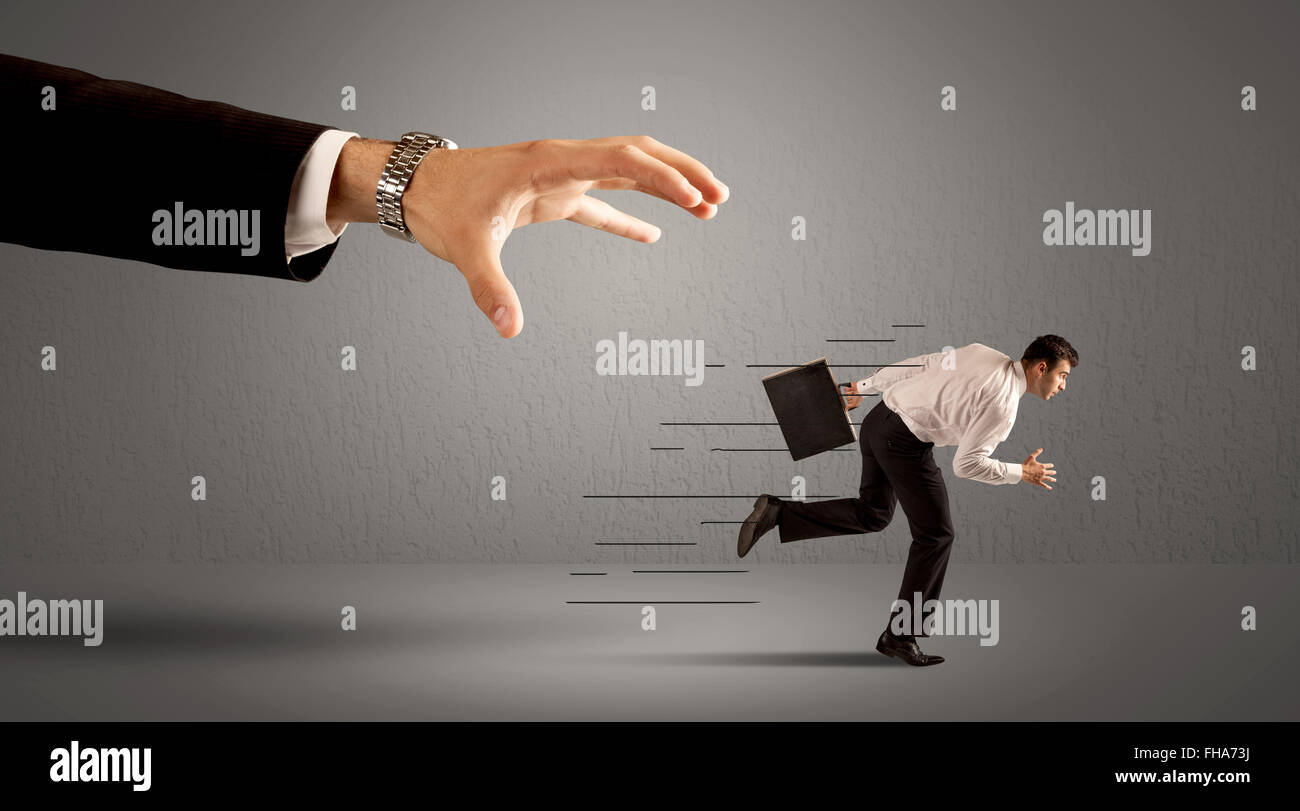Businessman running away from a huge hand Stock Photo - Alamy
