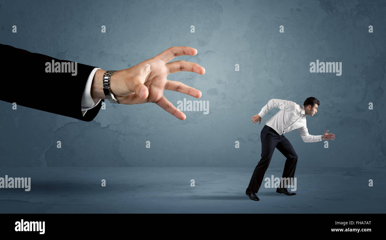 Business man running away from a huge hand concept Stock Photo - Alamy
