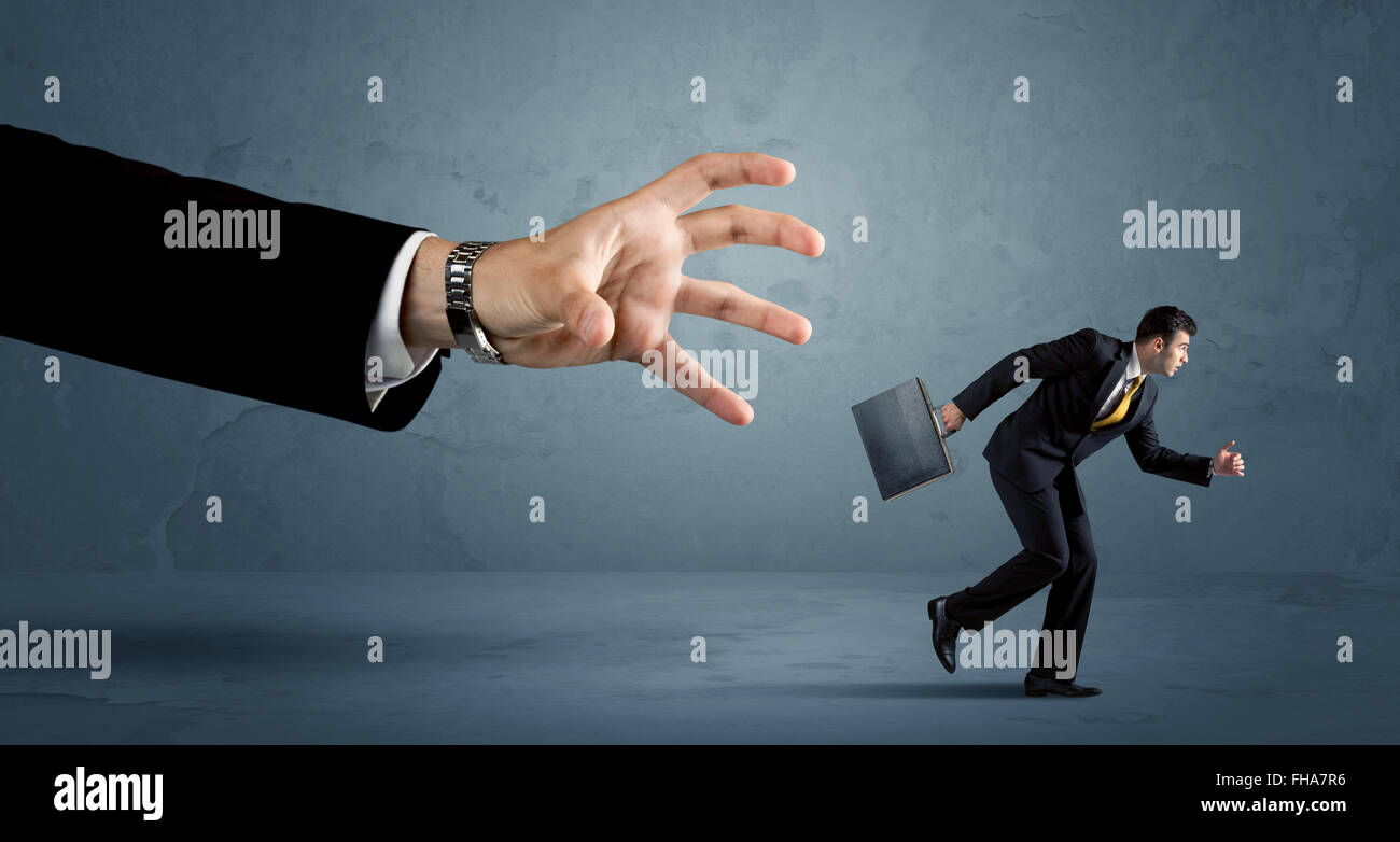 Business man running away from a huge hand concept Stock Photo - Alamy