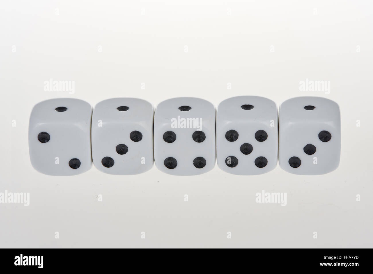 Five dices in a row, each showing one eye on the same side on a glass ...