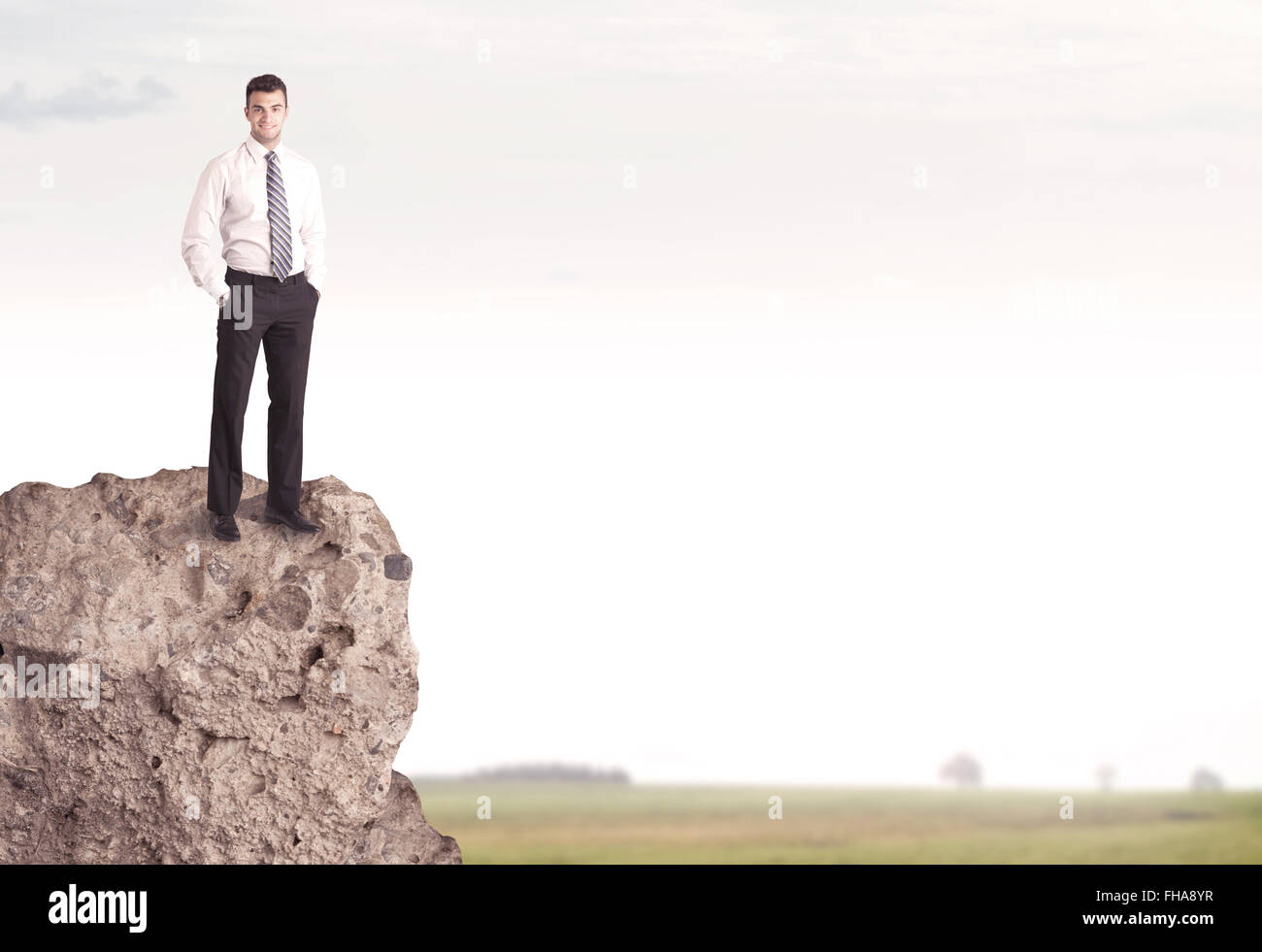 Happy salesman on cliff in the country Stock Photo - Alamy