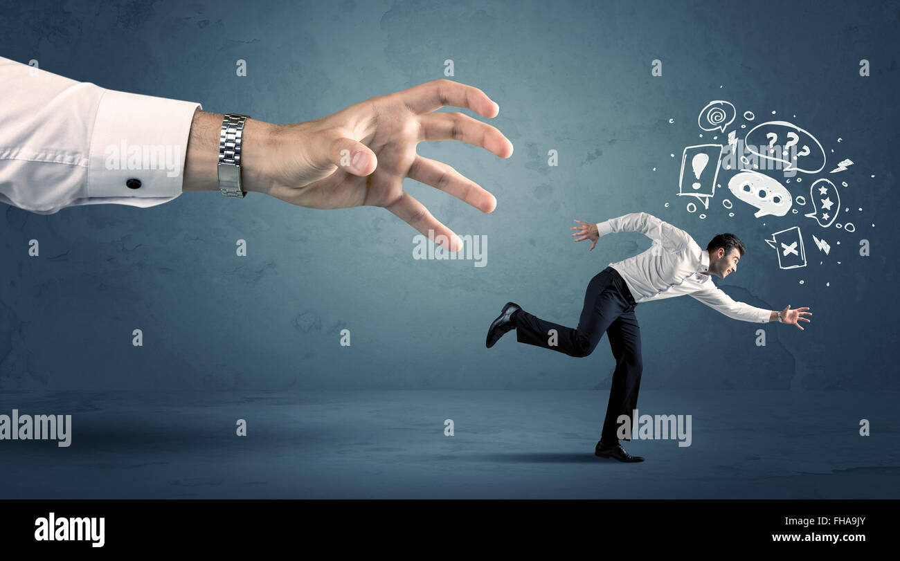Business man running from a big hand Stock Photo - Alamy