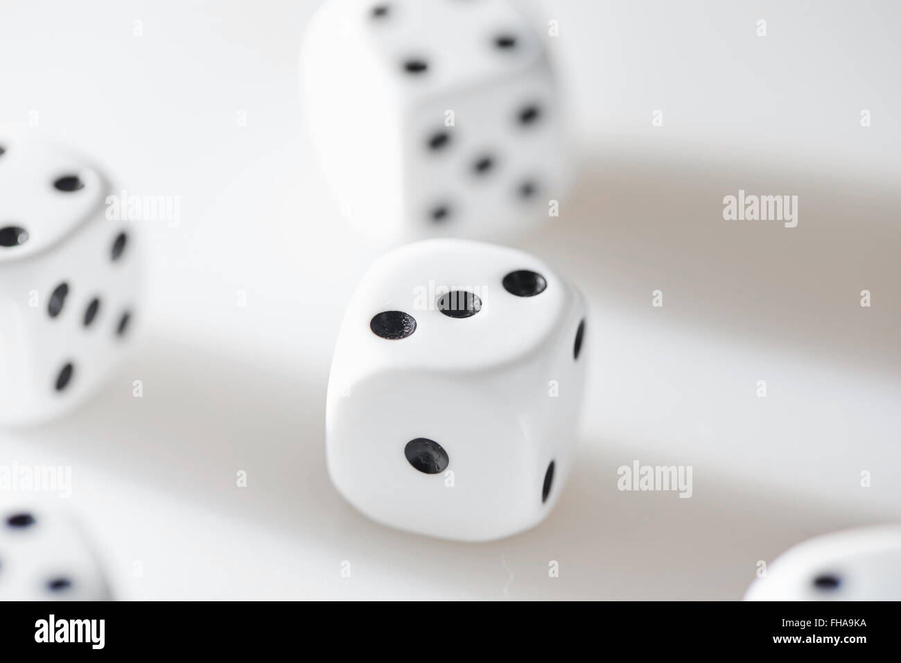 Several white dices with black eyes on a white table Stock Photo - Alamy