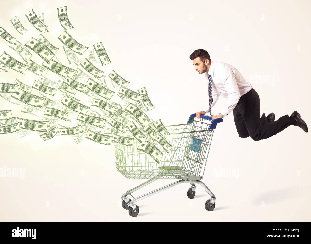 Businessman with shopping cart with dollar bills Stock Photo - Alamy
