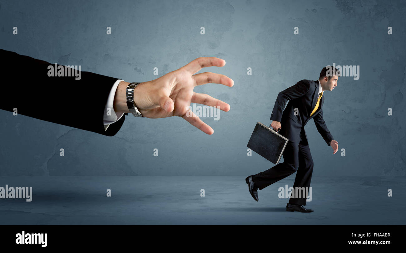 Business man running away from a huge hand concept Stock Photo - Alamy