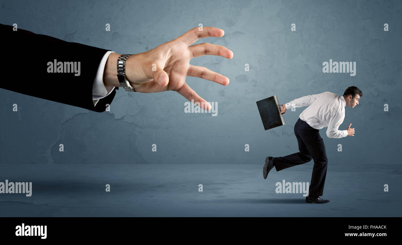 Business man running away from a huge hand concept Stock Photo - Alamy