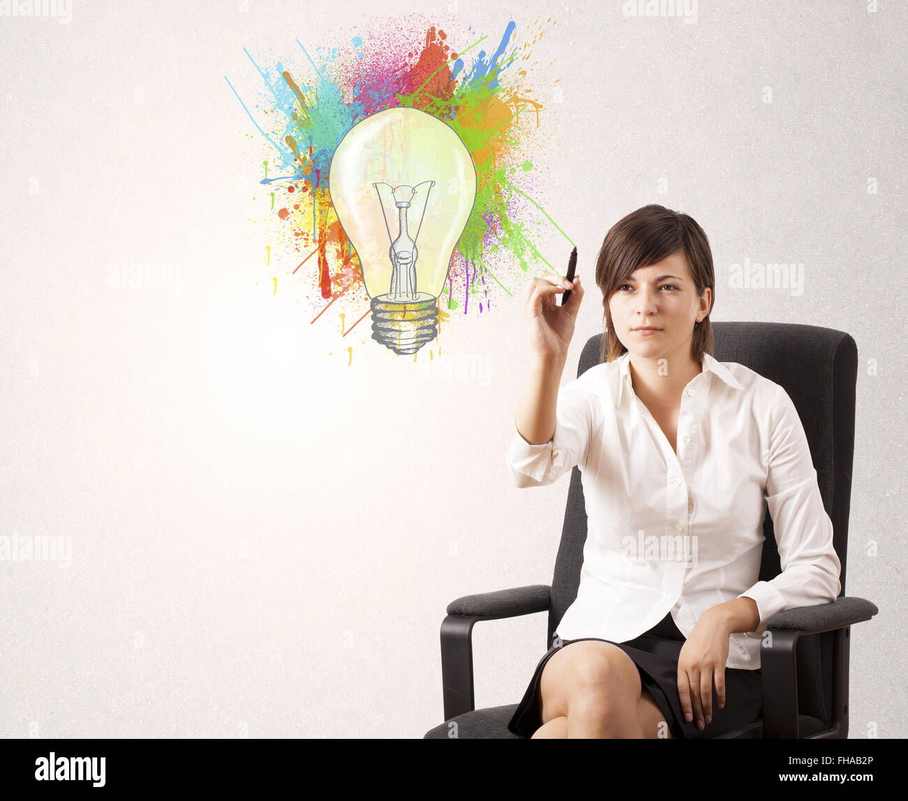 Young lady drawing a colorful light bulb with colorful splashes Stock ...