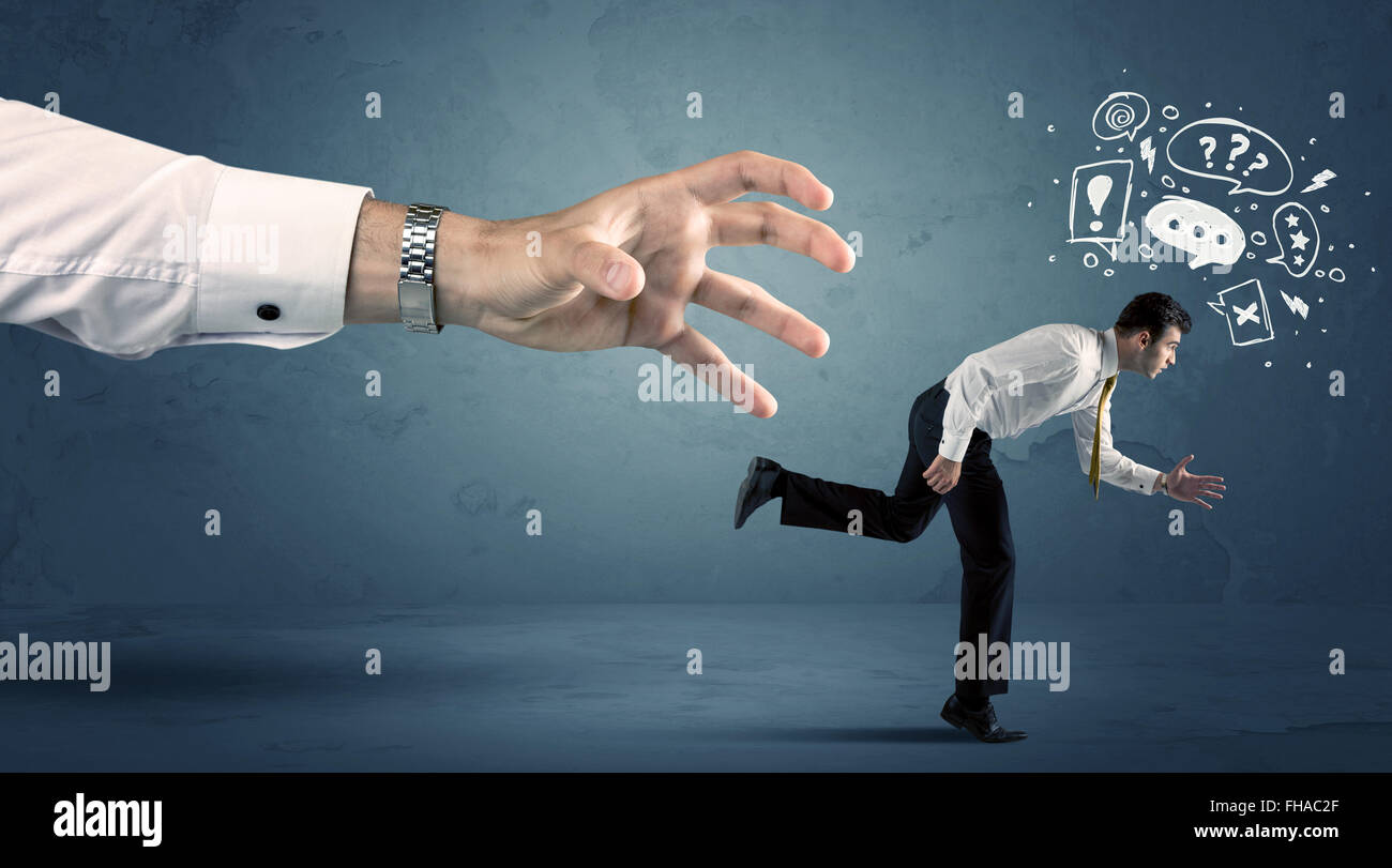 Business man running from a big hand Stock Photo - Alamy