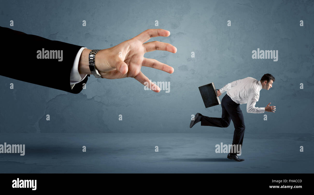 Business man running away from a huge hand concept Stock Photo - Alamy