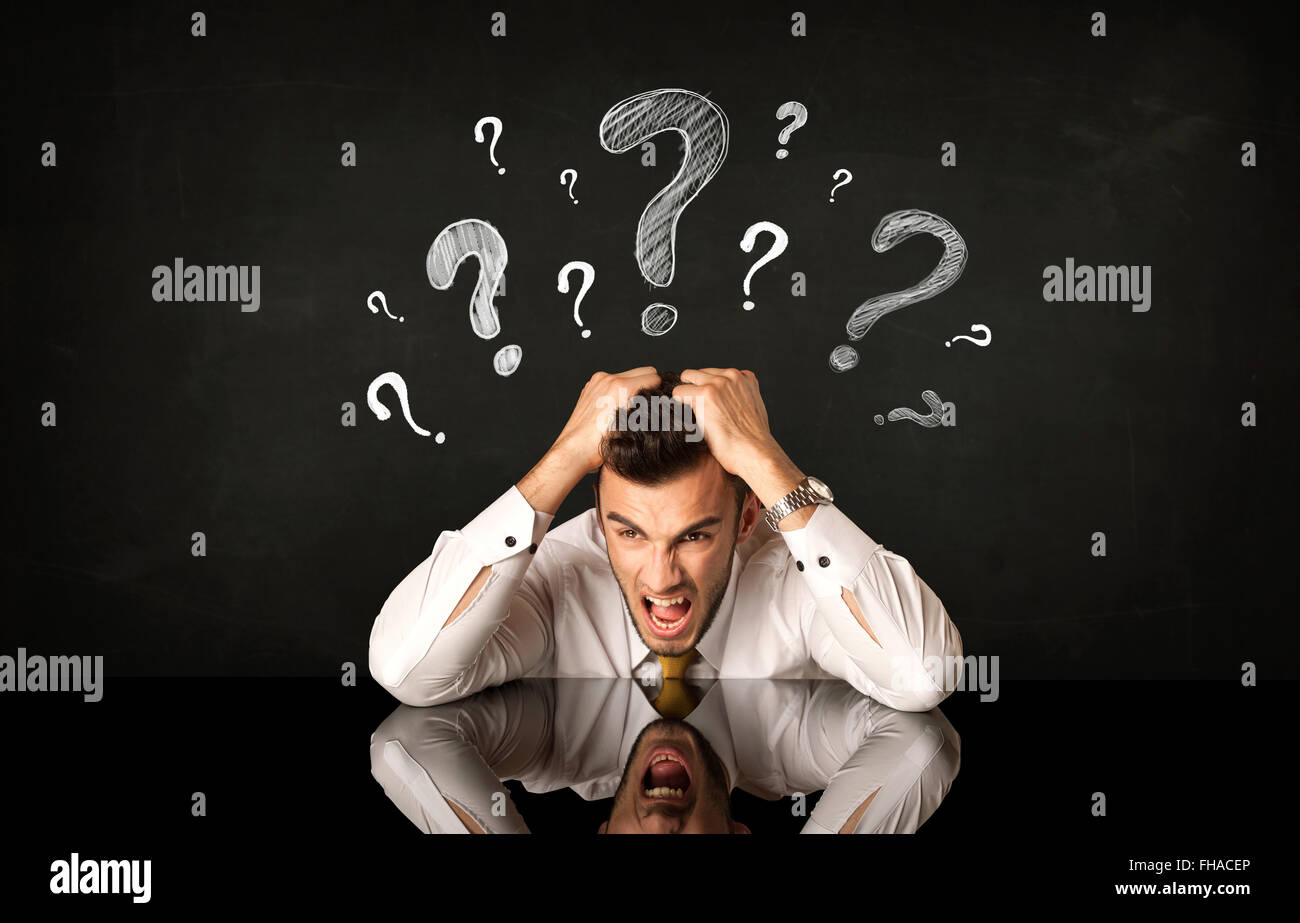 Sitting businessman under question marks Stock Photo - Alamy