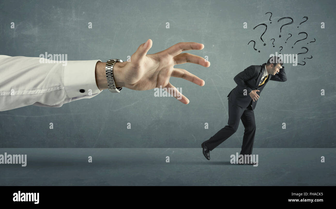Businessman with question marks running away from a big hand Stock ...