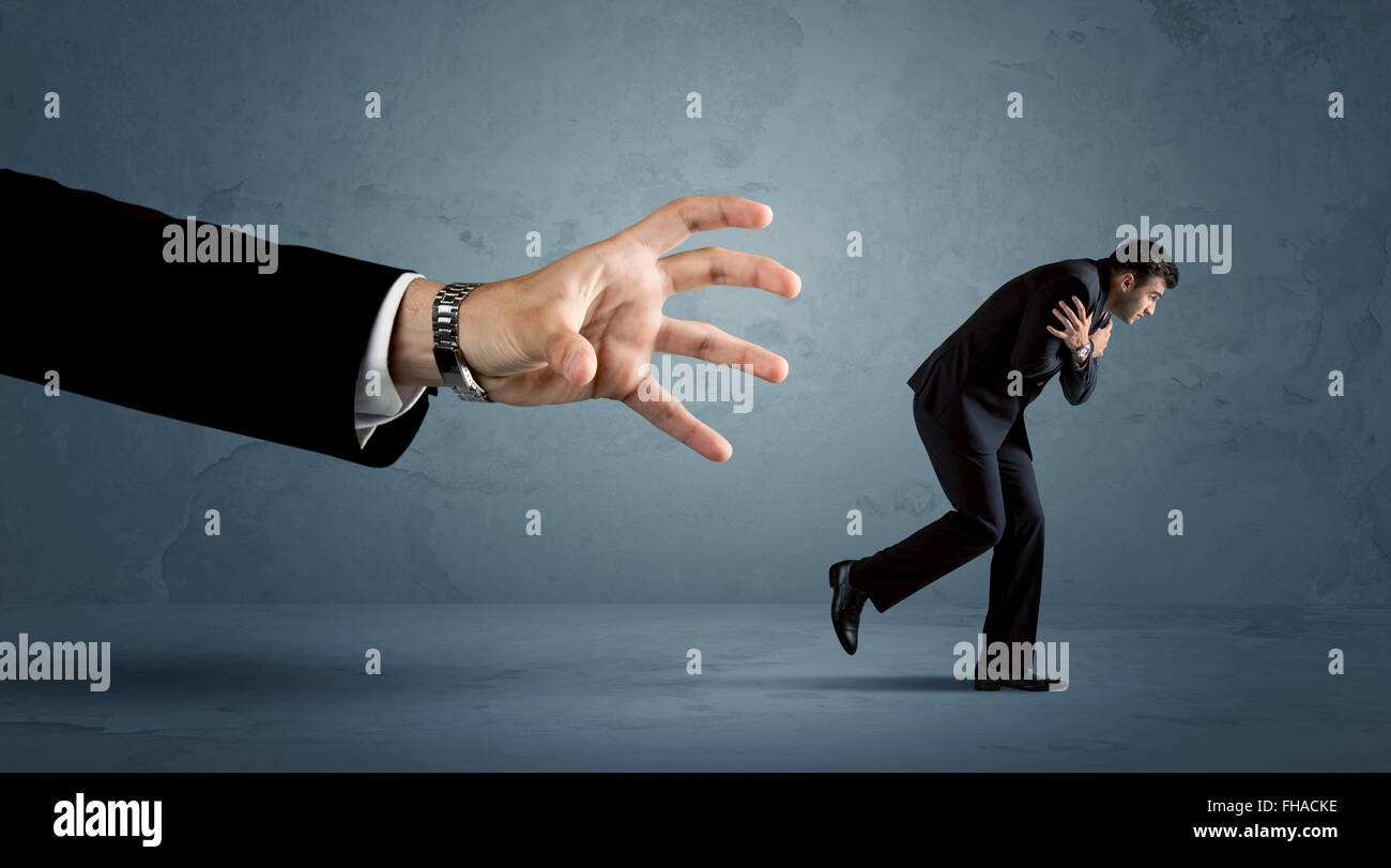 Business man running away from a huge hand concept Stock Photo - Alamy
