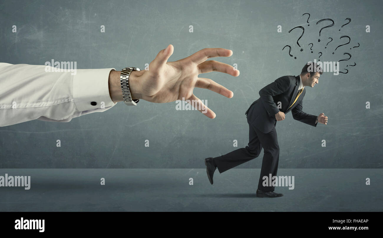 Businessman with question marks running away from a big hand Stock ...