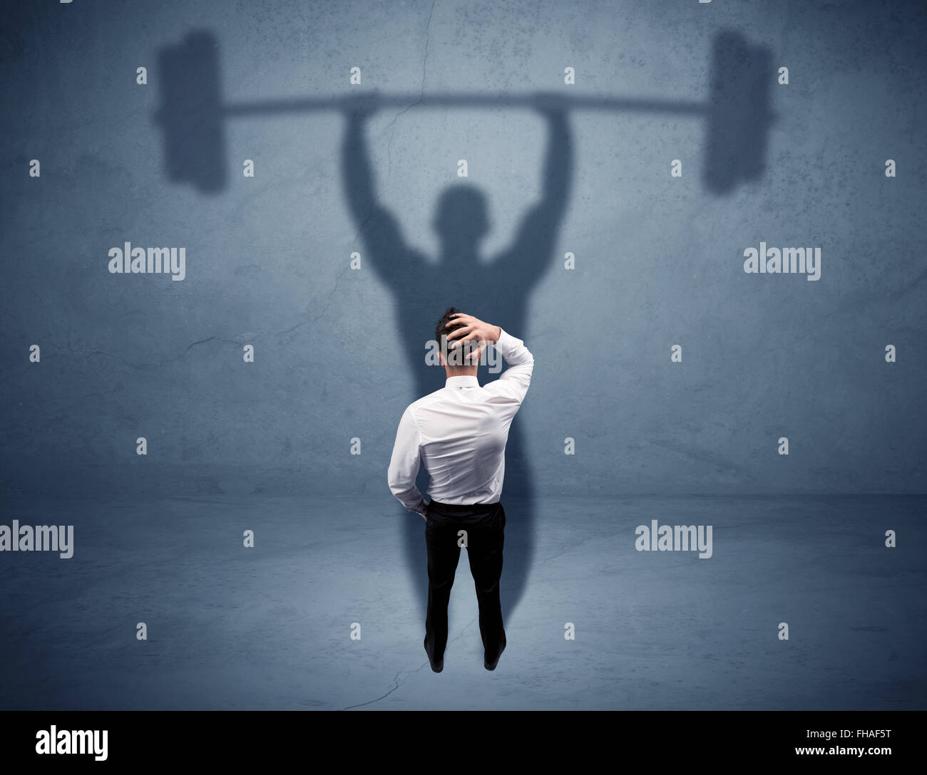Businessman with weight lifting shadow Stock Photo - Alamy