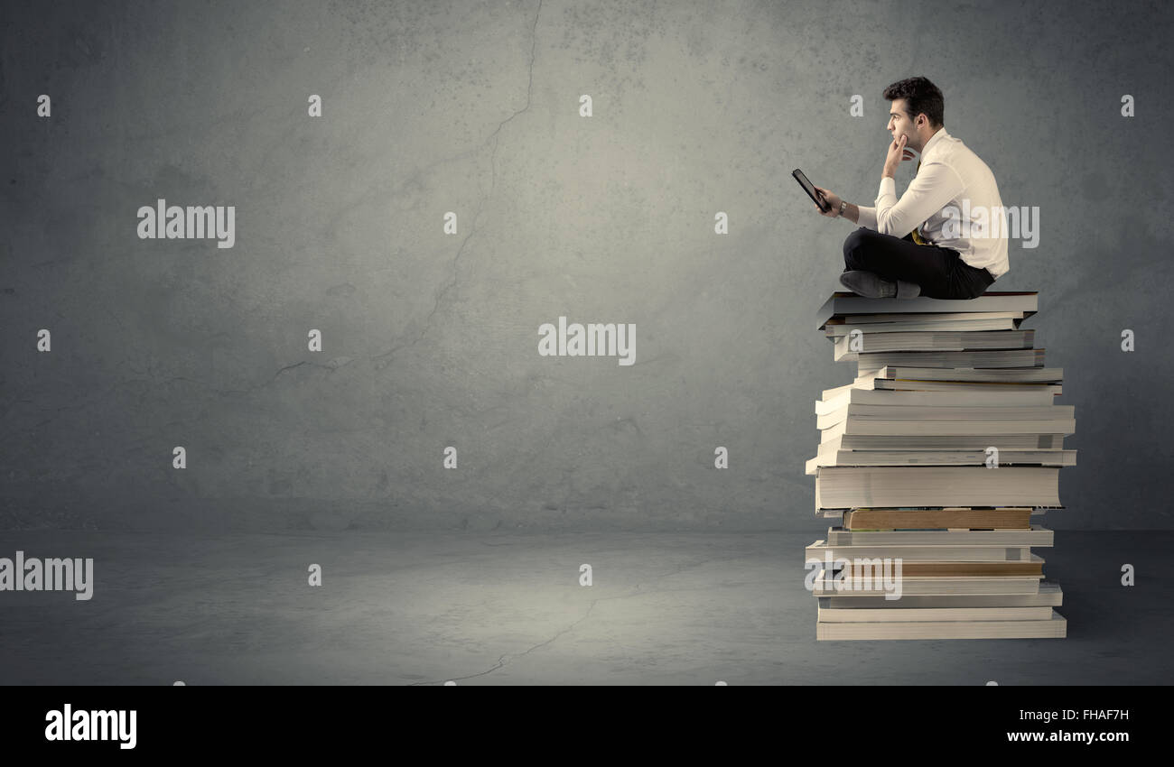 Student sitting on pile of books Stock Photo - Alamy
