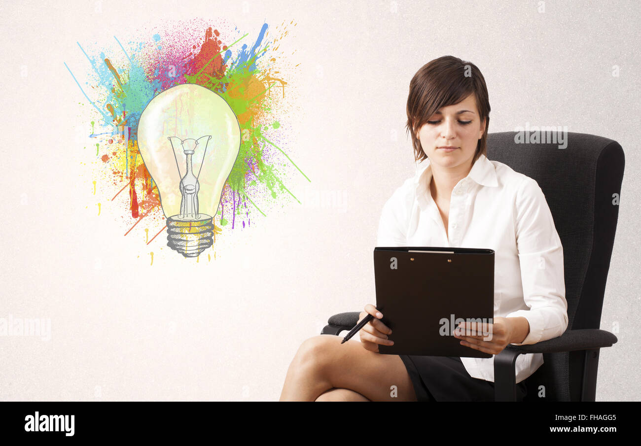 Young lady drawing a colorful light bulb with colorful splashes Stock ...