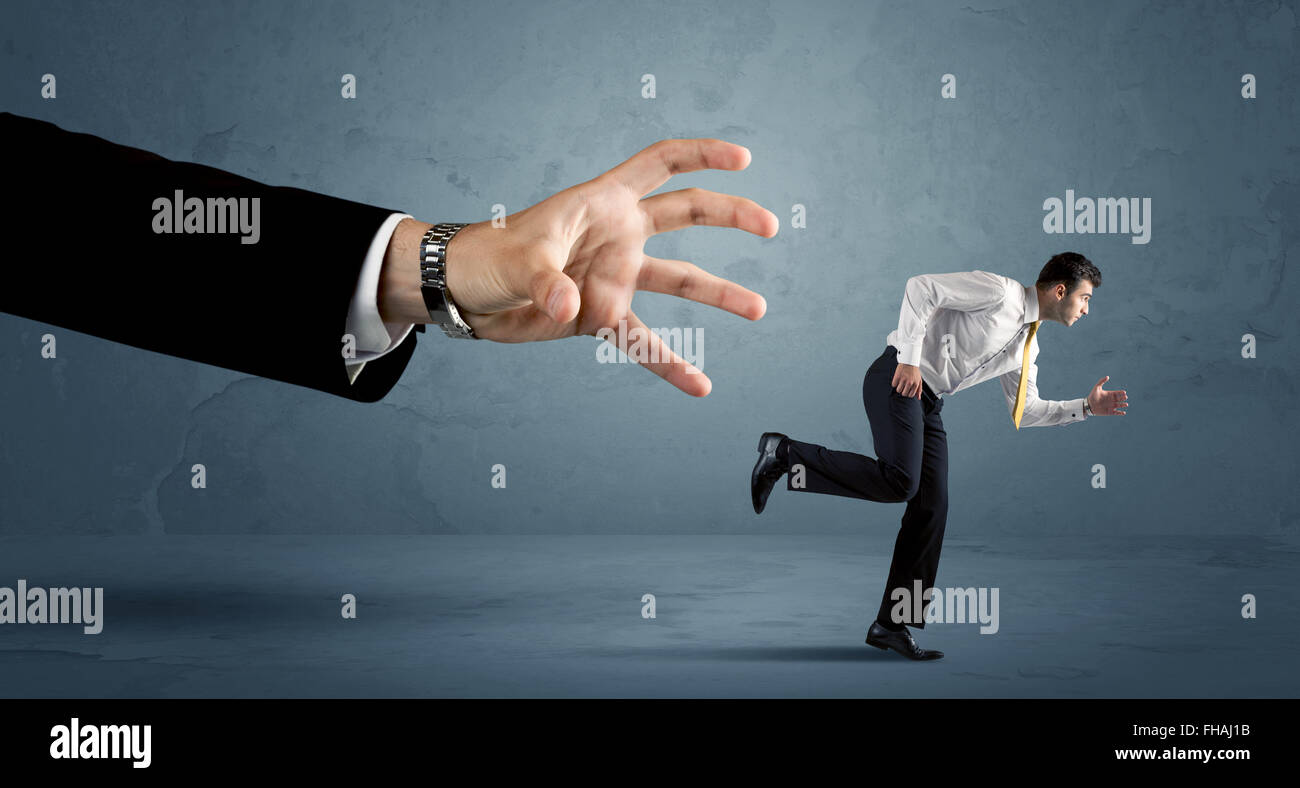 Business man running away from a huge hand concept Stock Photo - Alamy