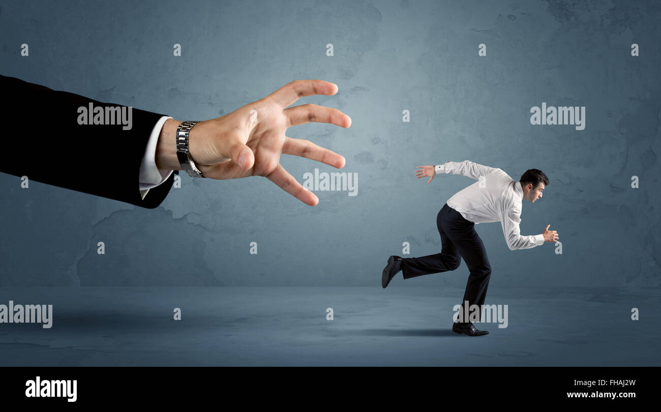 Business man running away from a huge hand concept Stock Photo - Alamy