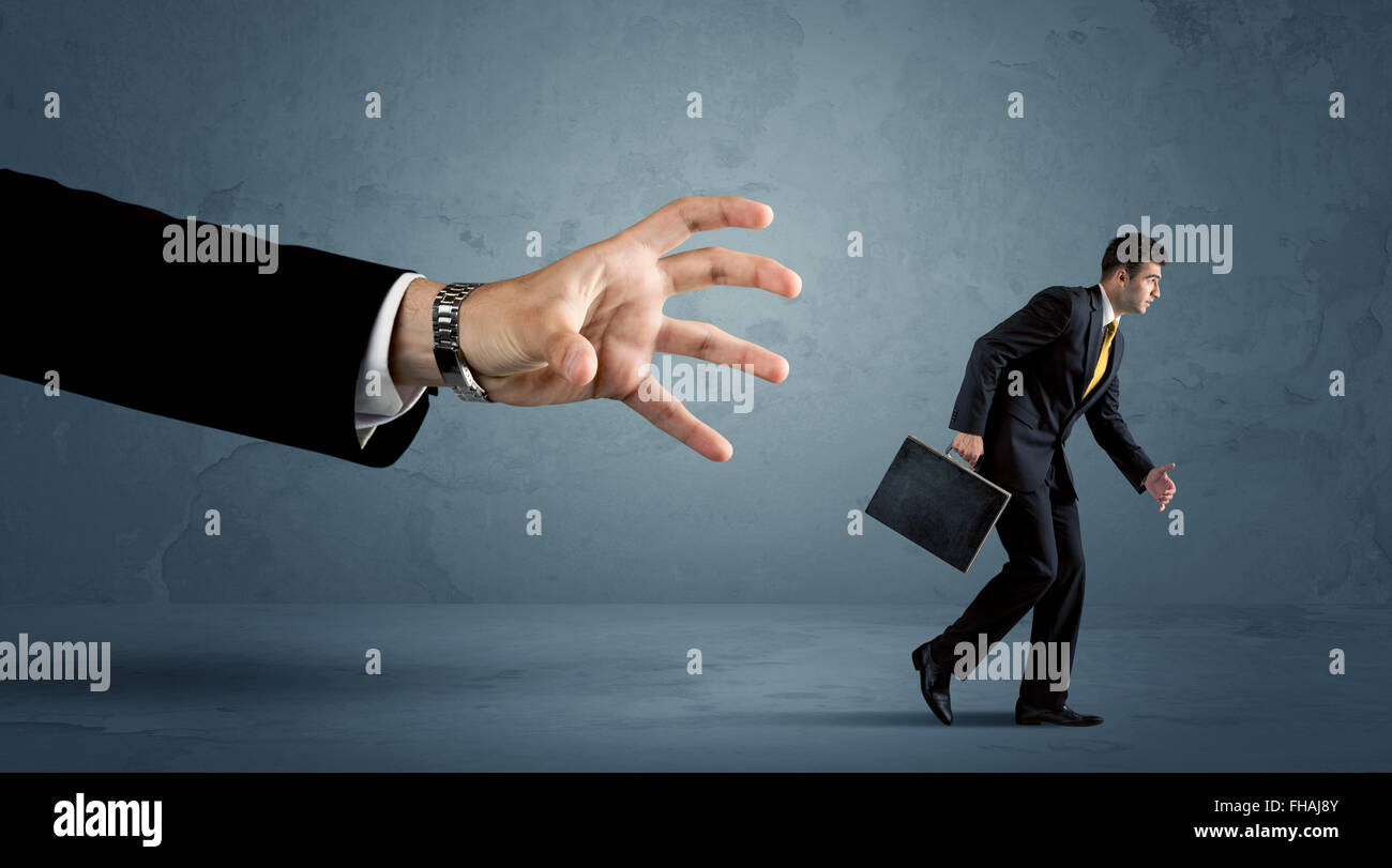 Business man running away from a huge hand concept Stock Photo - Alamy