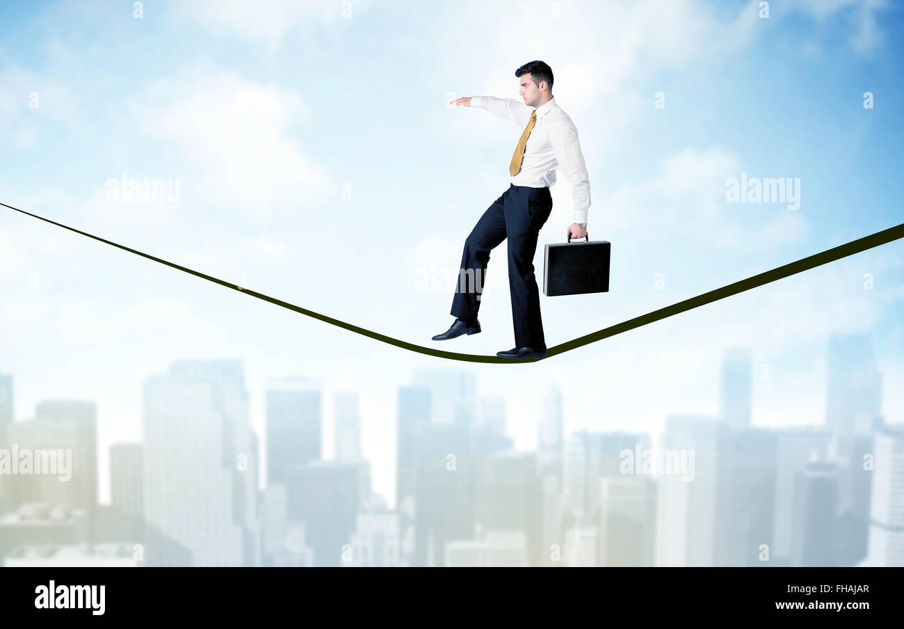 Salesman walking on rope above the city Stock Photo - Alamy