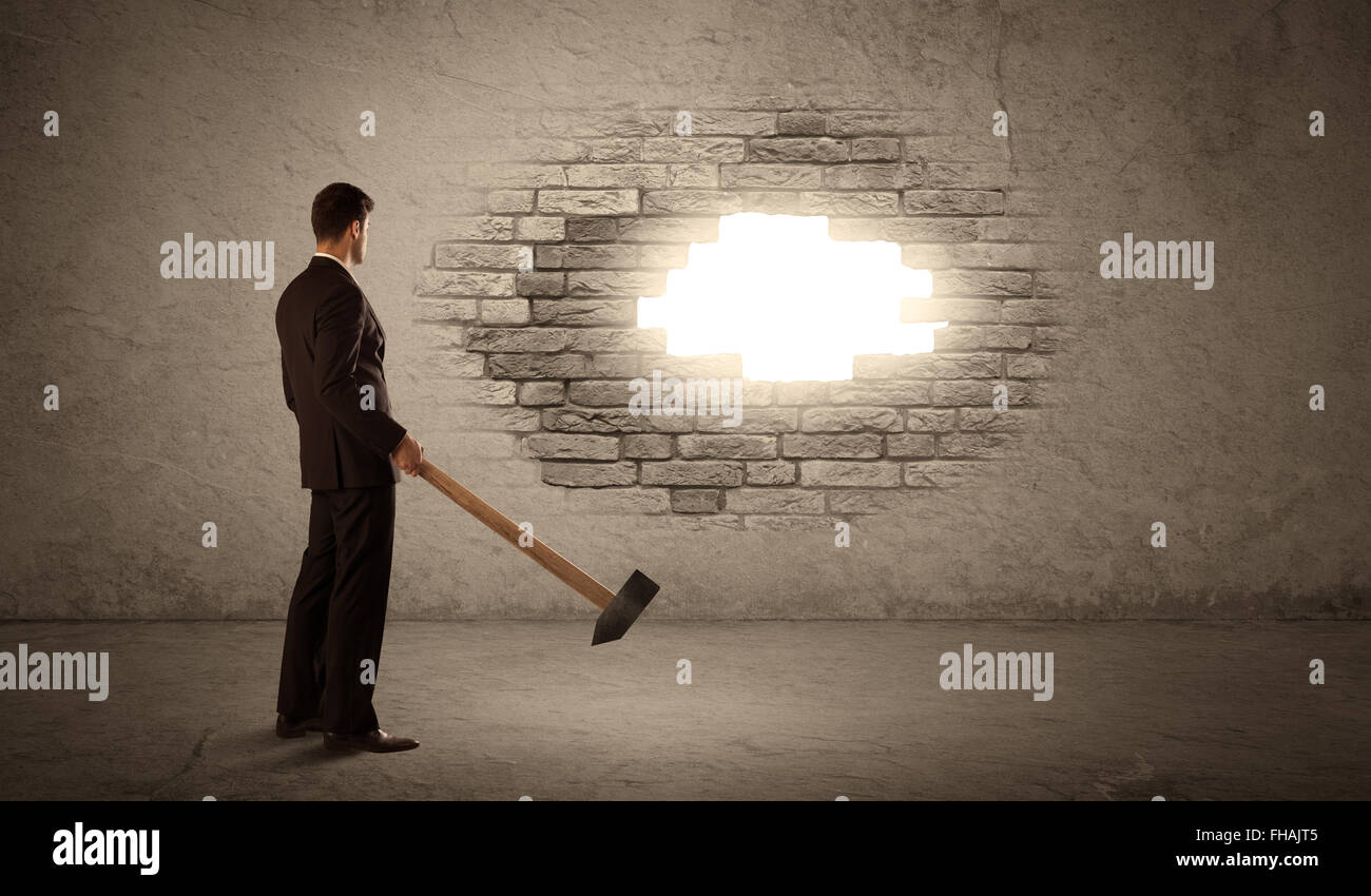 Business man hitting brick wall with hammer and opening a hole Stock ...