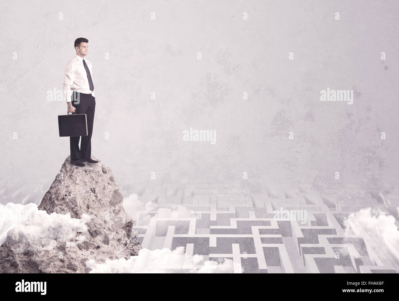 Businessman on cliff above labyrinth Stock Photo - Alamy