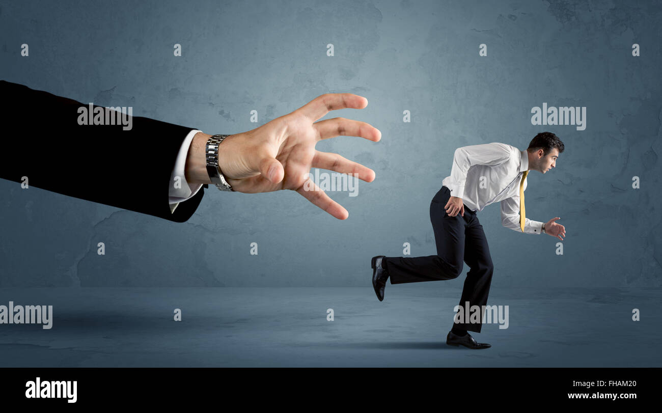 Business man running away from a huge hand concept Stock Photo - Alamy