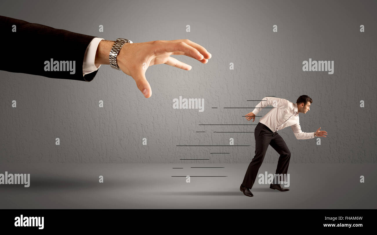Businessman running away from a huge hand Stock Photo - Alamy